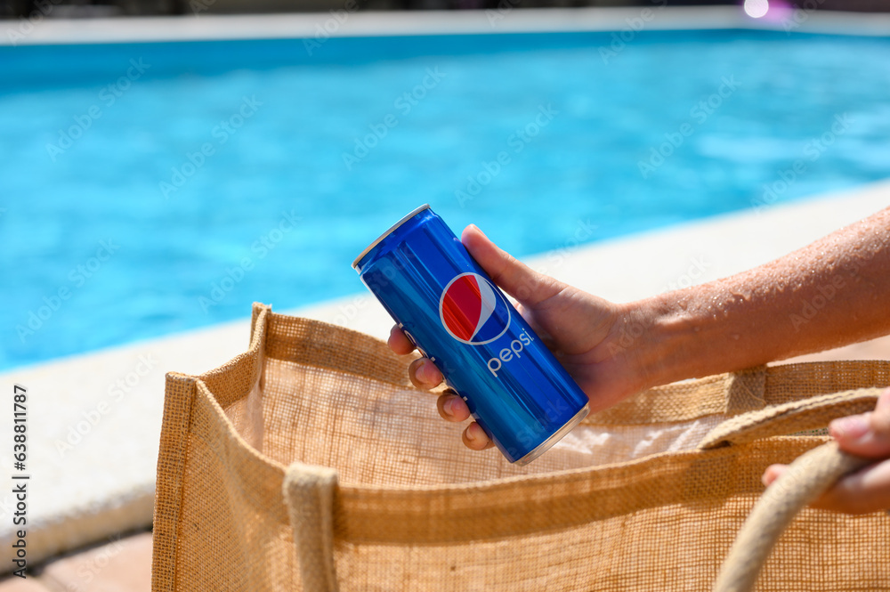 Anapa, Russia - July 23, 2023: The girl at the pool takes out a can of ...