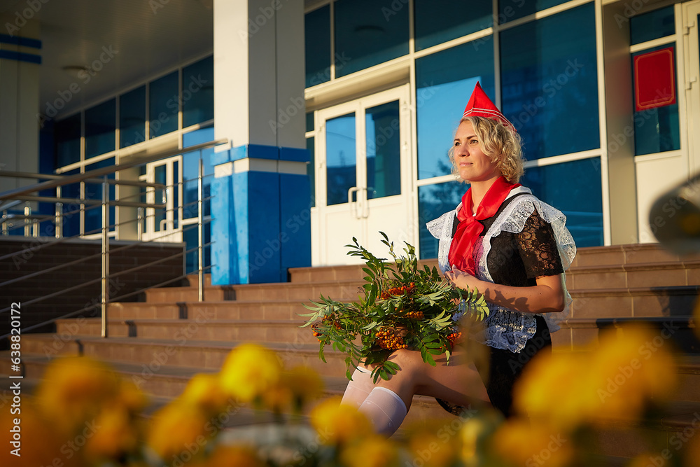 Girl in black school uniform, white apron and red tie on steps of ...