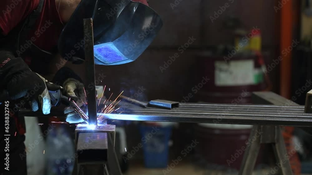 Welder or blacksmith, with his welder, welding steel and iron pipe ...