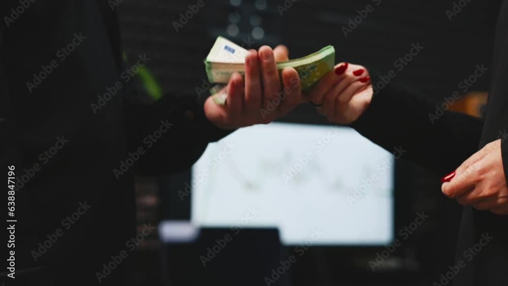 A business woman gives money and shakes hands with a businessman ...