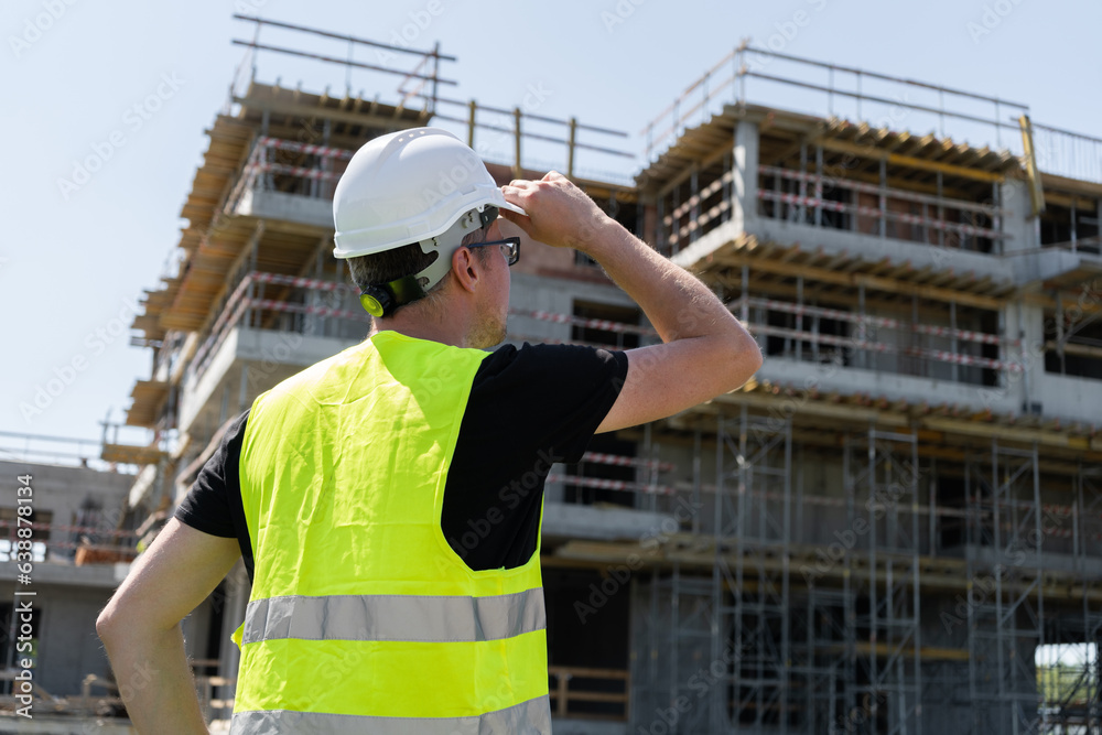 Male engineer at the construction site of a building during an ...