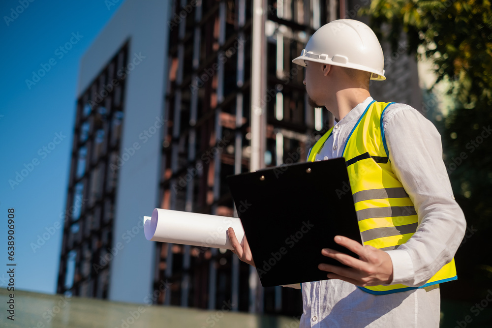 Civil engineer using a tablet, planning a project, builds a modern ...