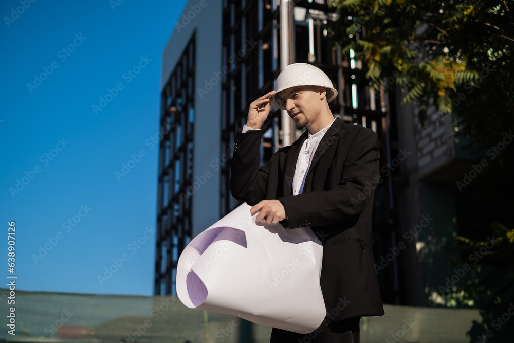 professional male engineer in special uniform and helmet holding ...