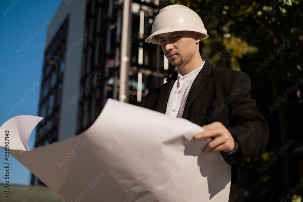 professional male engineer in special uniform and helmet holding ...