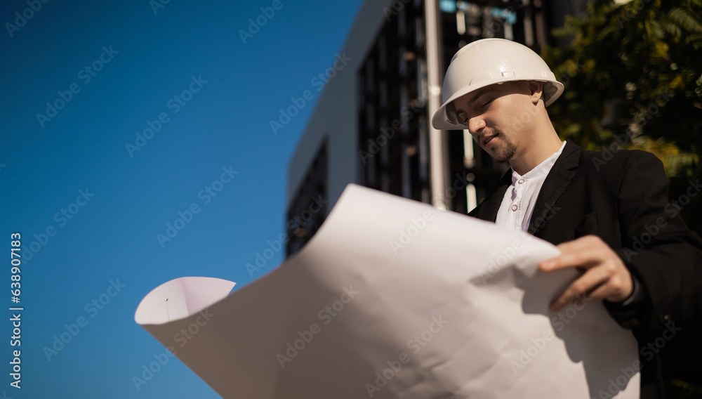 professional male engineer in special uniform and helmet holding ...