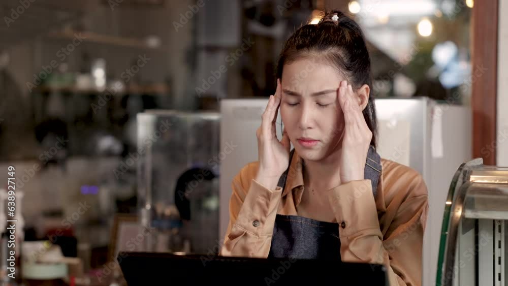 Asian young barista girl get headache and frustrated with over-expenses ...