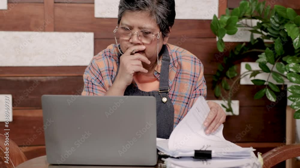 Asian senior elderly retirement woman concentrates on bookkeeping for ...