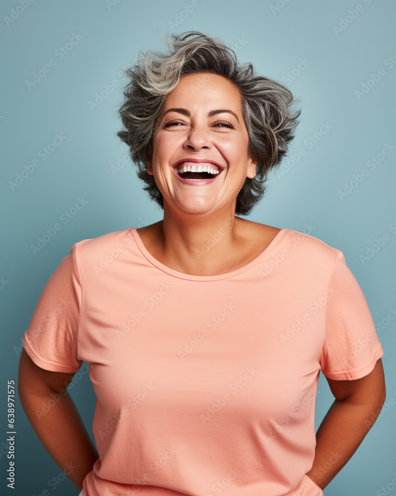 Portrait of a beautiful plus size senior woman smiling on a pastel ...