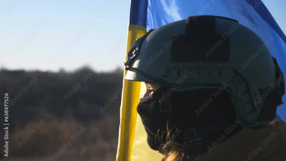 Dolly shot of girl in military helmet and balaclava holds a waving ...