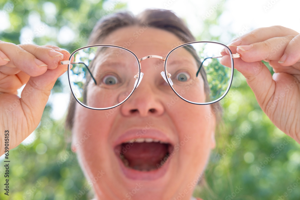 surprised woman in glasses looks in surprise, funny joke, female joker ...