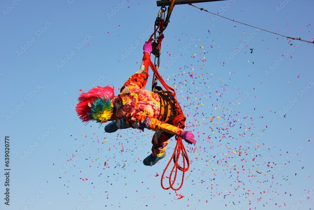 an acrobat in colored clothes in the air against the background of the ...