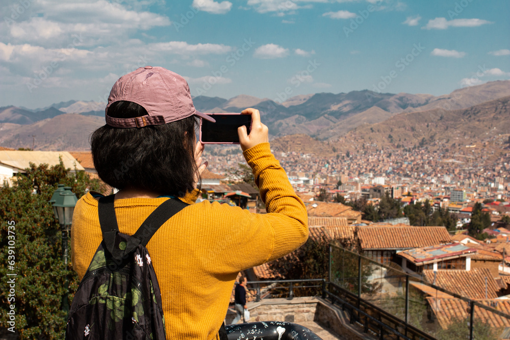 Turista con celular en la mano tomando fotografías la ciudad de Cusco ...