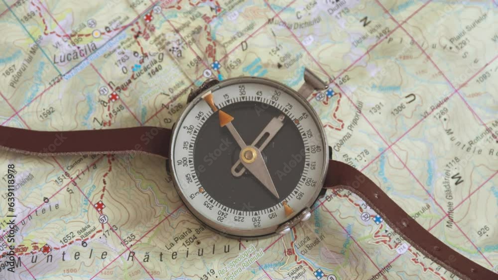 Old compass on map with mountain trails. Compass indicating north on ...