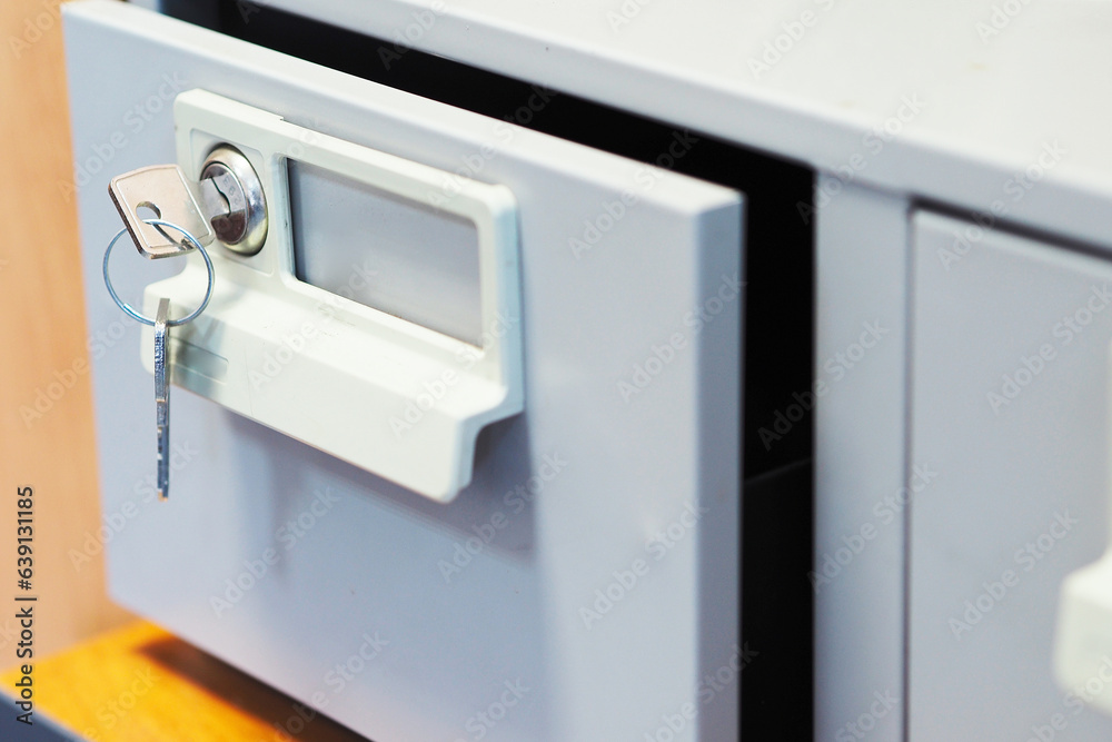 It is open gray document box with key in lock. Open cell drawer with ...
