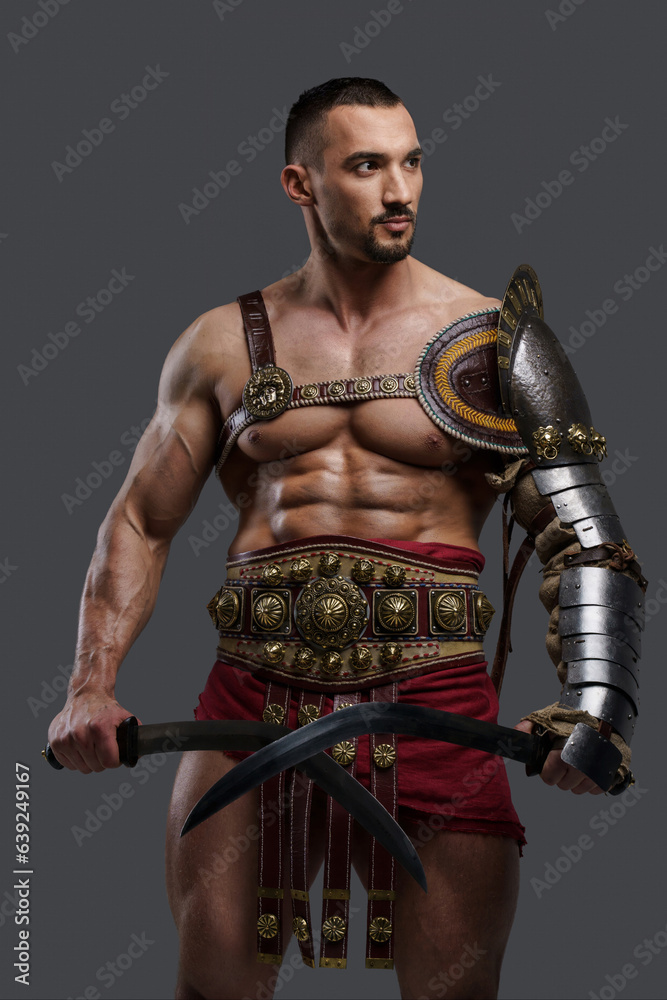 Elegant gladiator in stylish light armor holds two gladii in hands ...