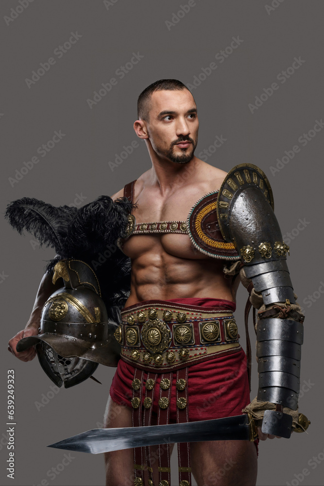 Brutal warrior in light armor clenches a gladius and helmet in hands ...