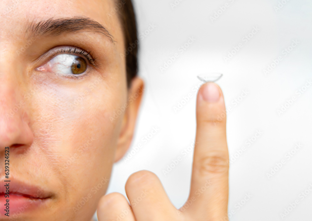 millennial woman putting or remove from eye contact lens close up ...