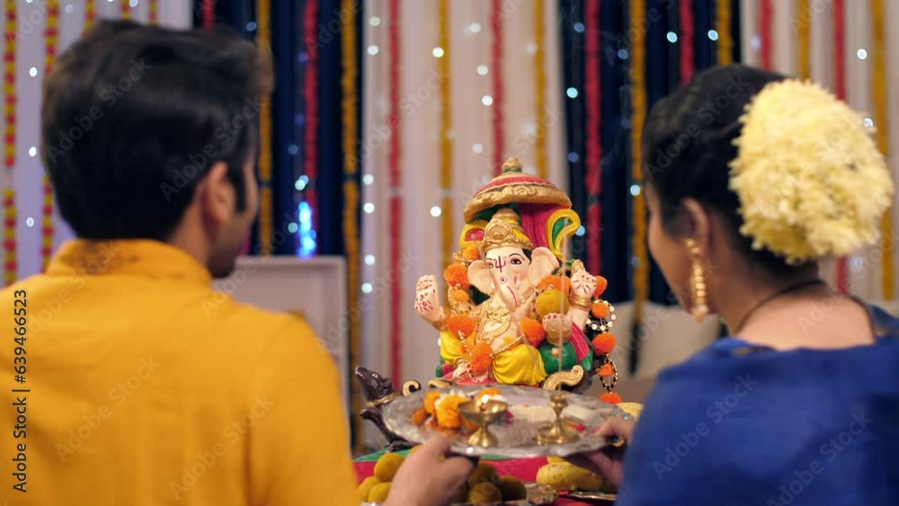 An Indian couple worshipping Lord Ganesha - puja ki thali festival ...