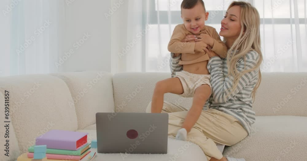 Awesome Blonde Mom With Infant Son On Knees Using PC Computer In Living ...