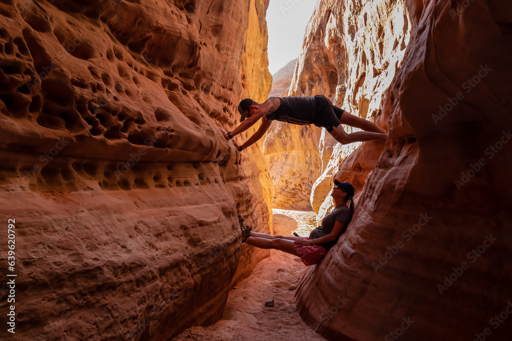 Couple climbing the walls in narrow Kaolin Wash slot canyon on White ...