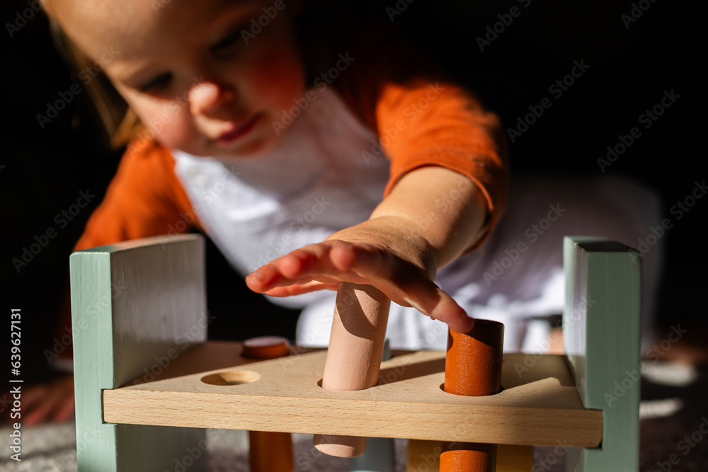 Toddler child playing with hammer pounding bench toy using hands to ...