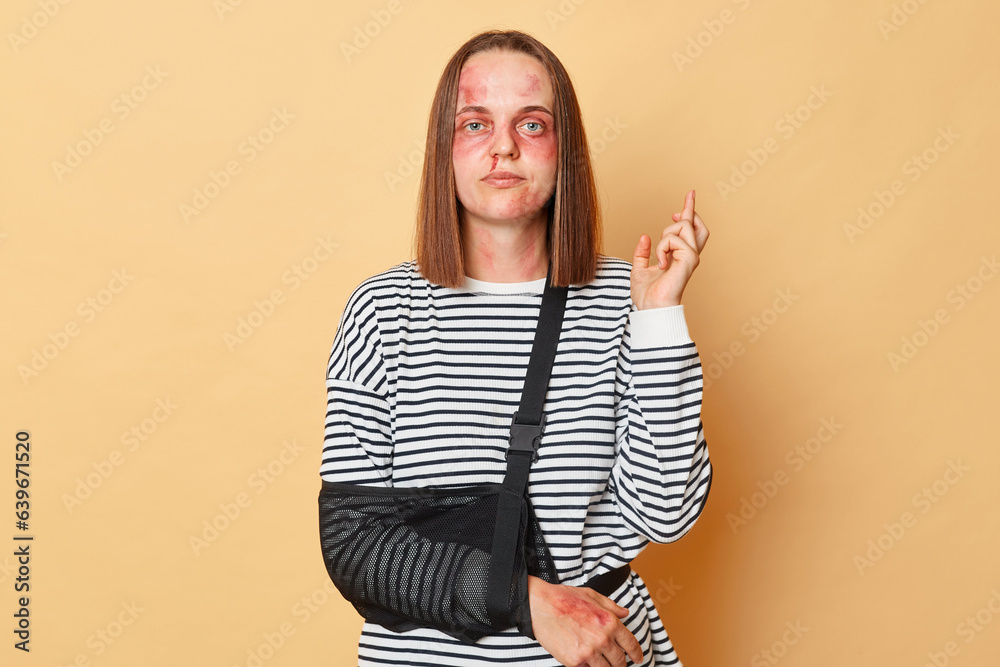 Serious sad woman in striped shirt with bandage and bruised skin ...