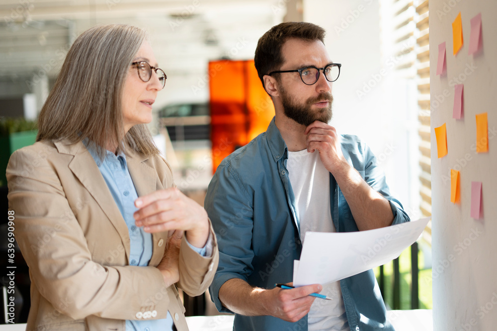 Senior business woman and successful scrum master talking, explaining ...