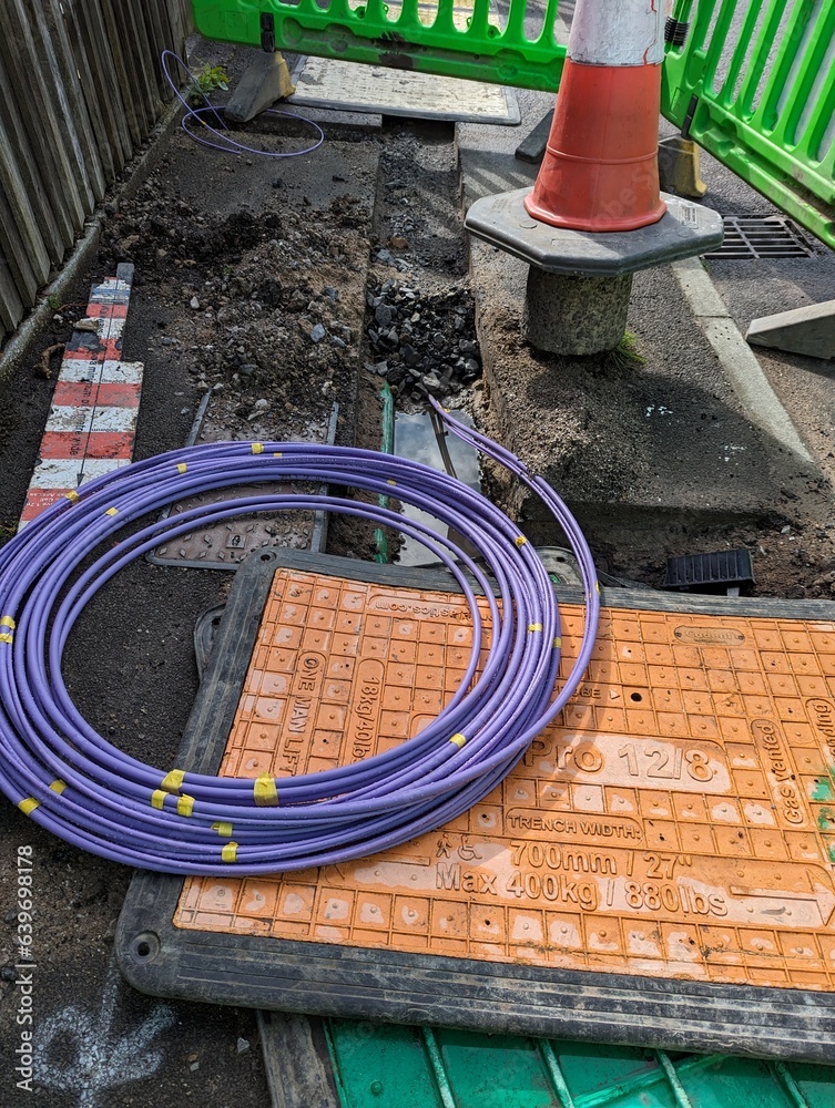 Fibre optic cable coming out of a trench curled up waiting to be ...