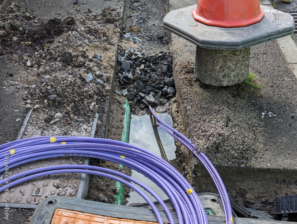 Fibre optic cable coming out of a trench curled up waiting to be ...