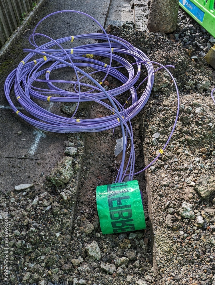Fibre optic cable coming out of a trench curled up waiting to be ...