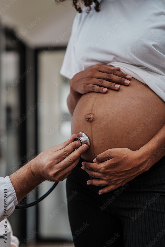 Male gynecologist doctor checking african american pregnant woman ...