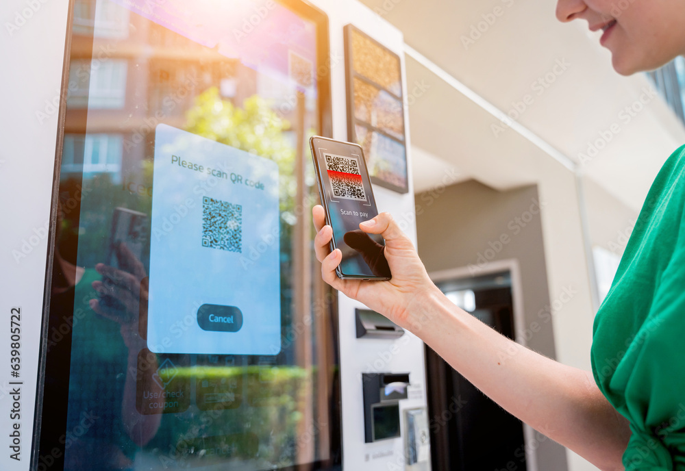 Young woman paying for coffee at vending machine using contactless ...