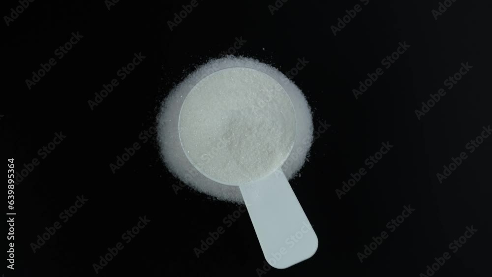 Disodium monohydrogen citrate in measuring scoop, top view. Pile of ...