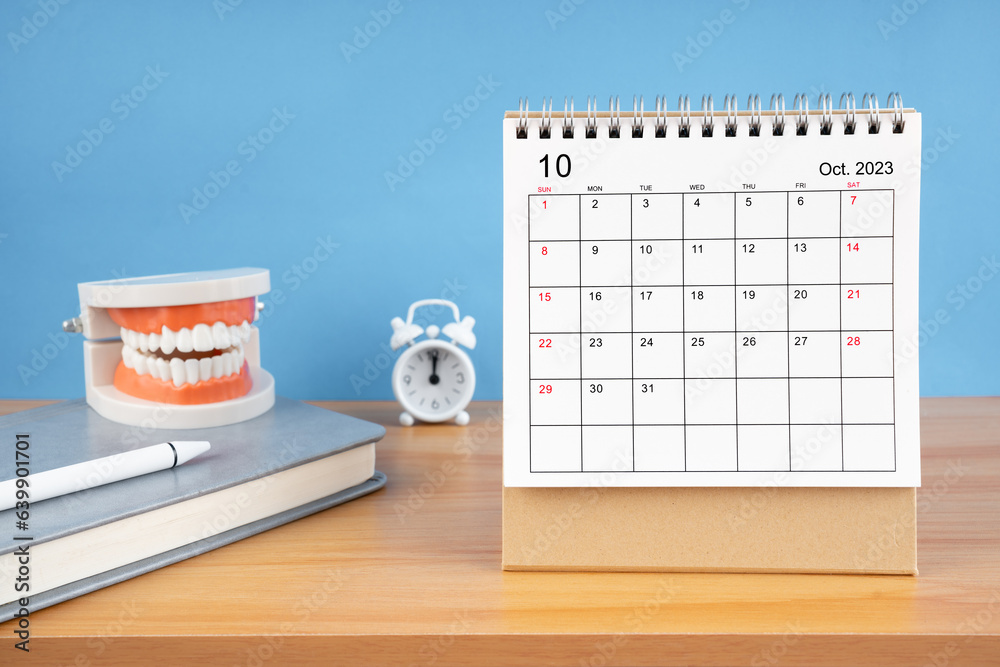 The October monthly desk calendar for 2023 year and model dentures on ...