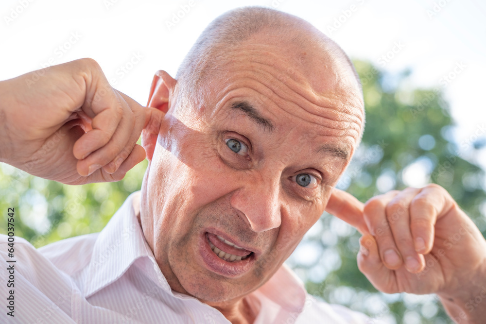 funny senior, man 65 years old holds to ear, male face, facial ...