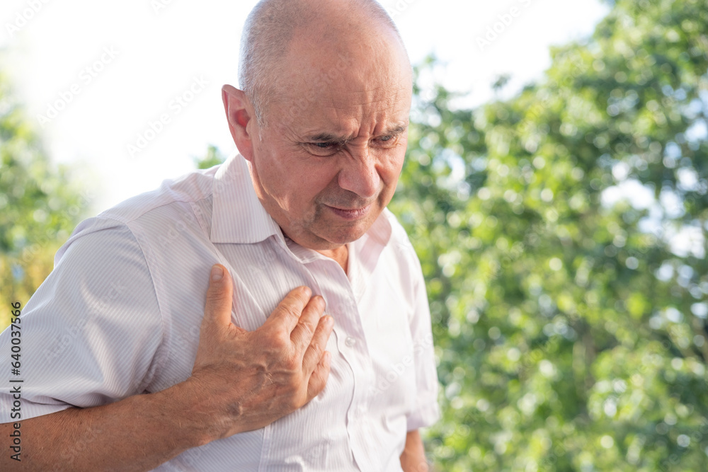 senior, mature man 60-65 years old holds to heart, sudden chest pain ...