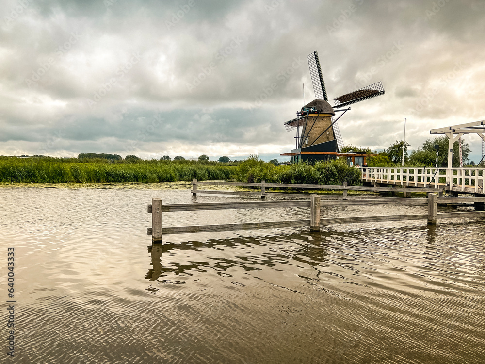 Foto de Iconic and historical wooden Dutch windmill and canal system ...