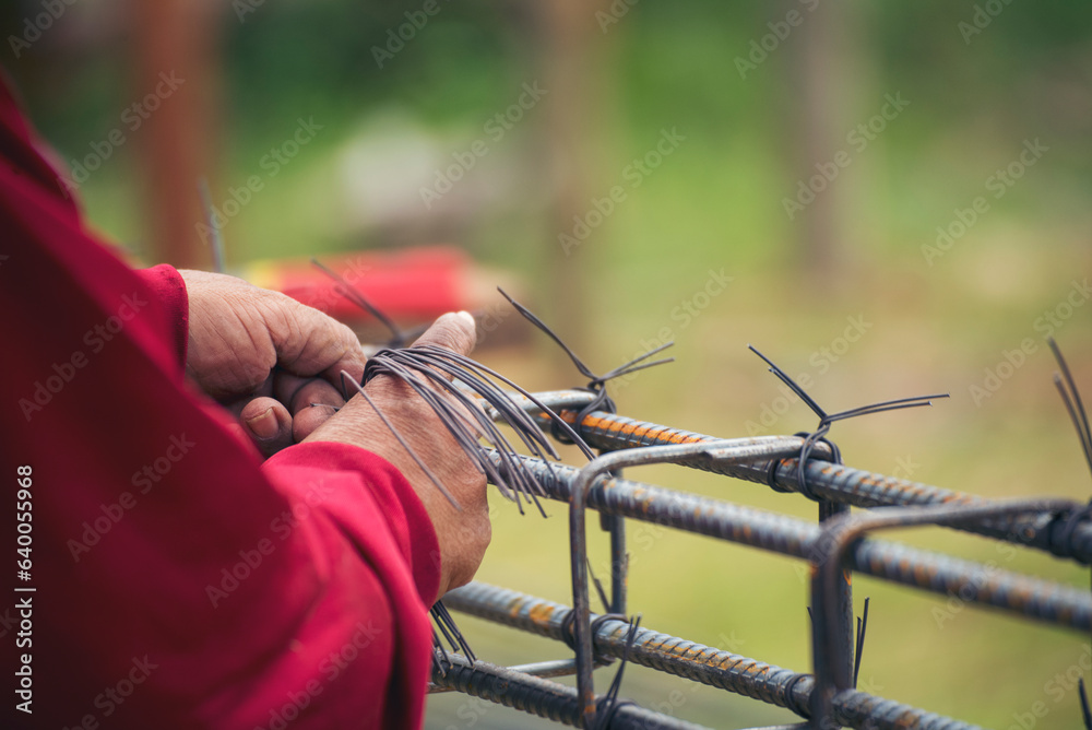 Men hands using pincer pliers iron wire reinforcement of concrete work ...