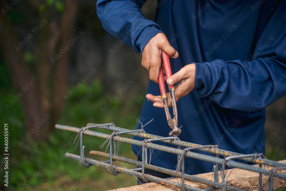 Men hands using pincer pliers iron wire reinforcement of concrete work ...