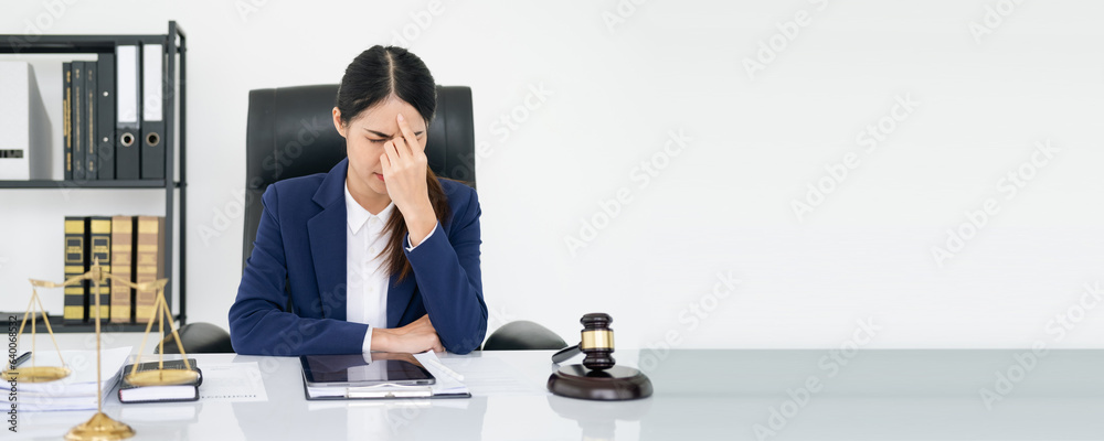 lawyer sitting at her desk with worried and exhausted expression ...