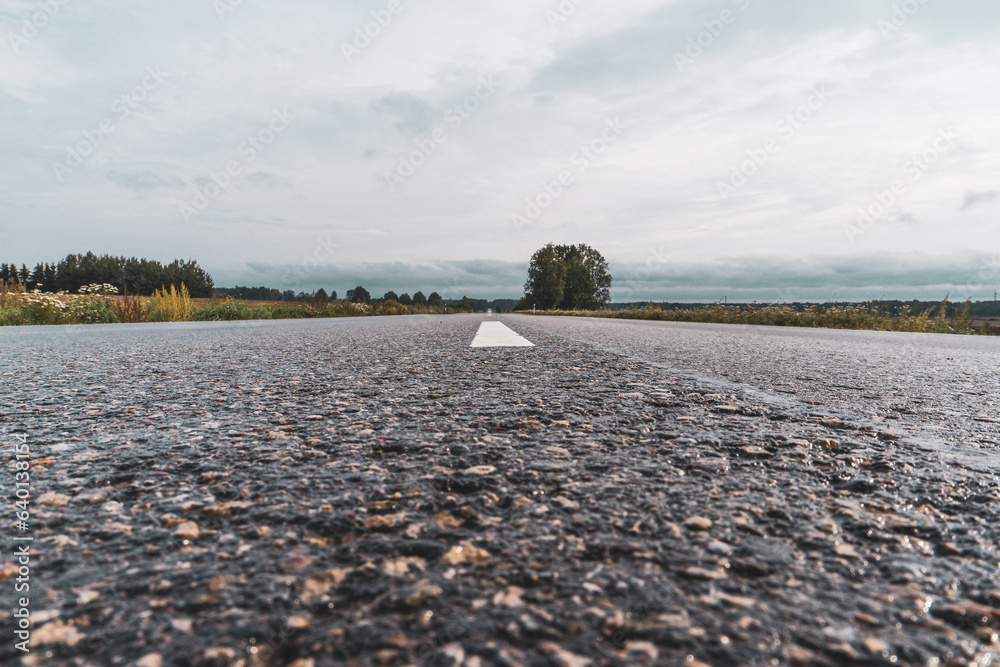 Asphalt road with a view in the distance and a white broken dividing ...