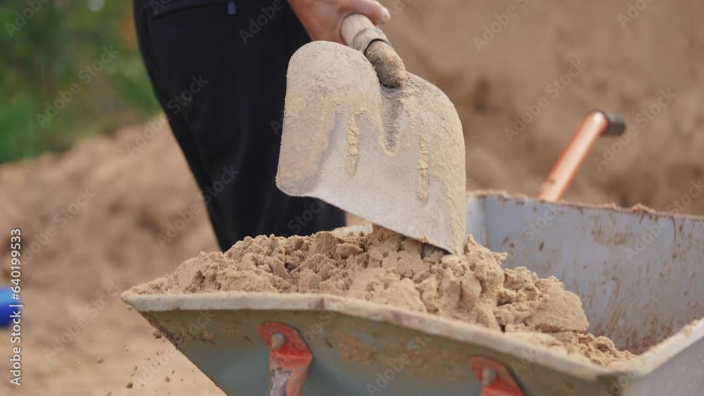wheelbarrow for transportation of sand close-up. construction workers ...