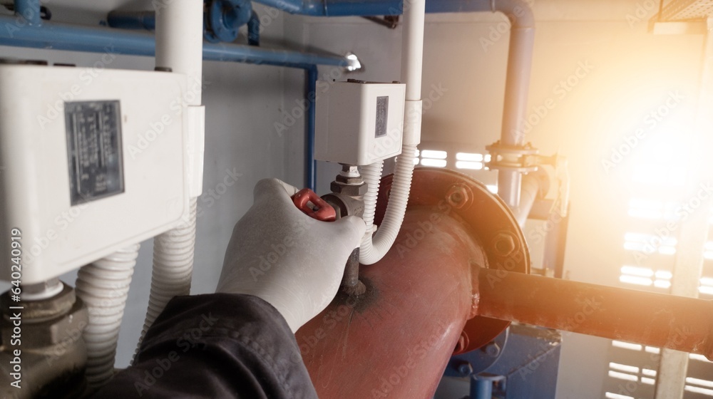 Engineer check the pressure control switch installed on the pipe water ...