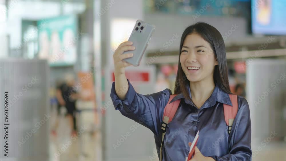 Girl with a backpack talking on video coll through mobile phone at the ...