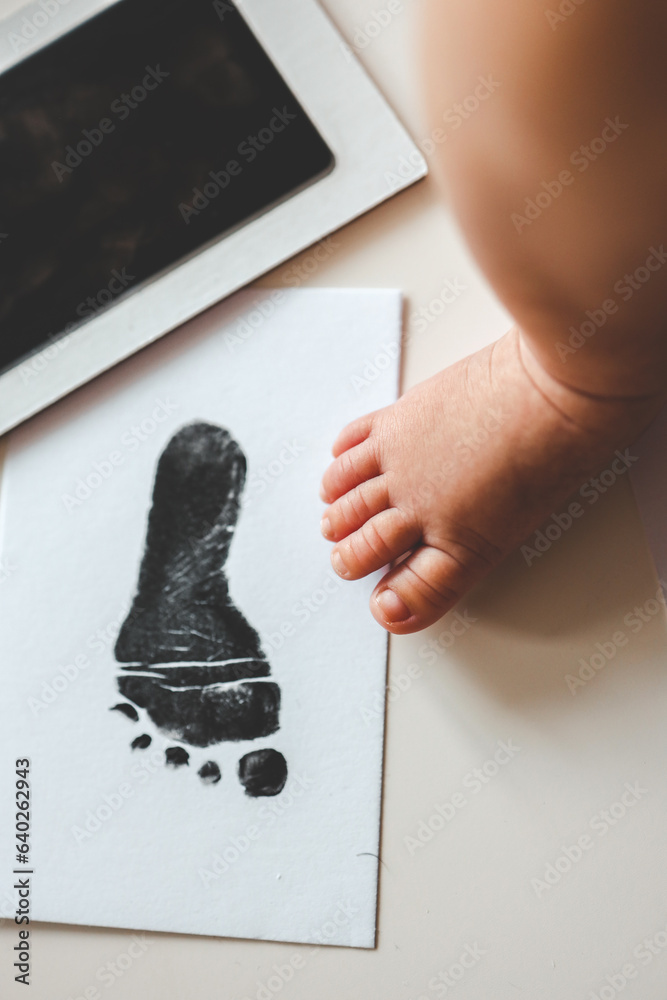 Baby footprints on white paper. Black footprint. The process of ...