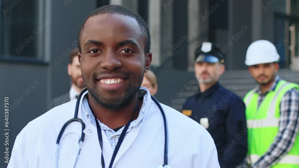 Portrait of african american doctor wearing white gown, smiling cheery ...