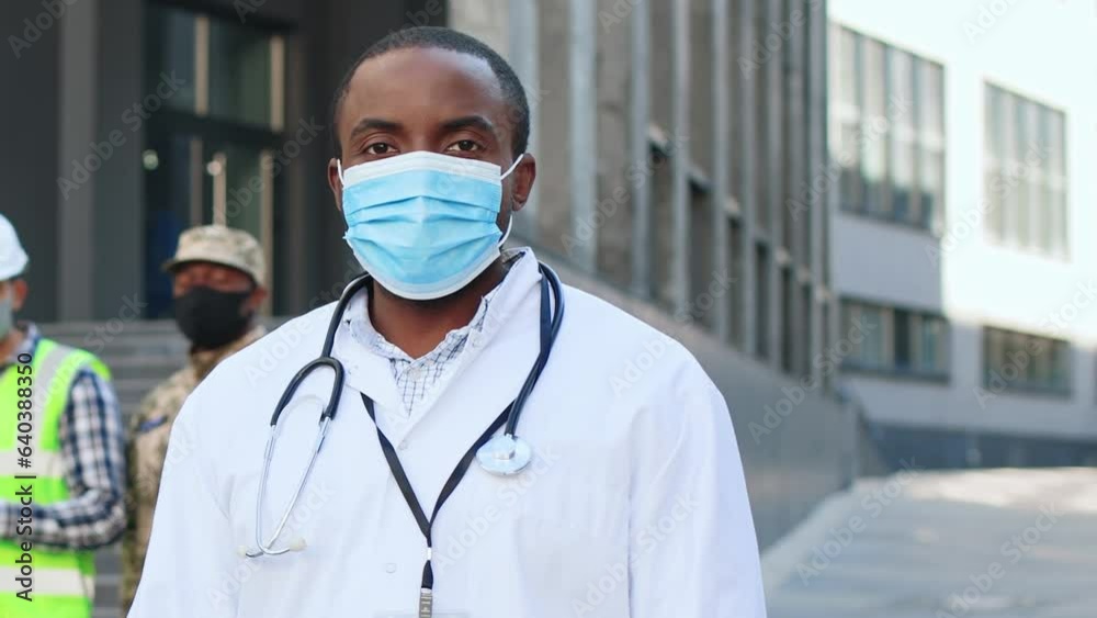 Waist up portrait view of multiracial doctor wearing protective mask ...