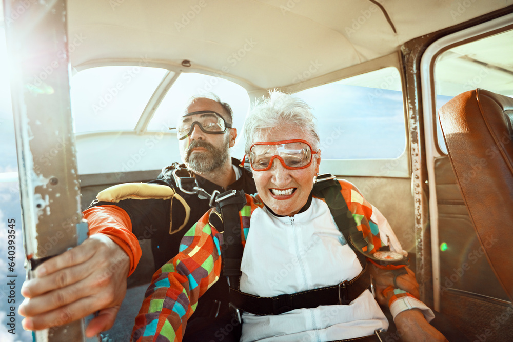 Scared senior woman getting ready to skydive out of an airplane with ...