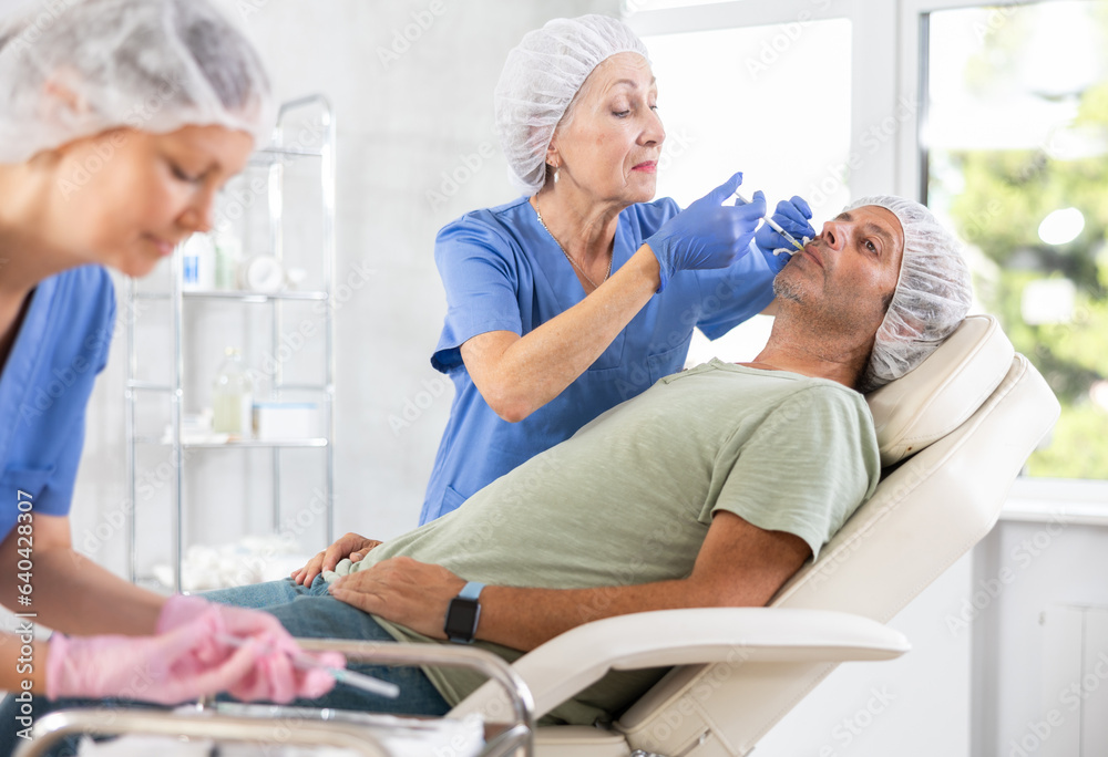 Team of cosmetologists provide anti-aging injection services to male ...