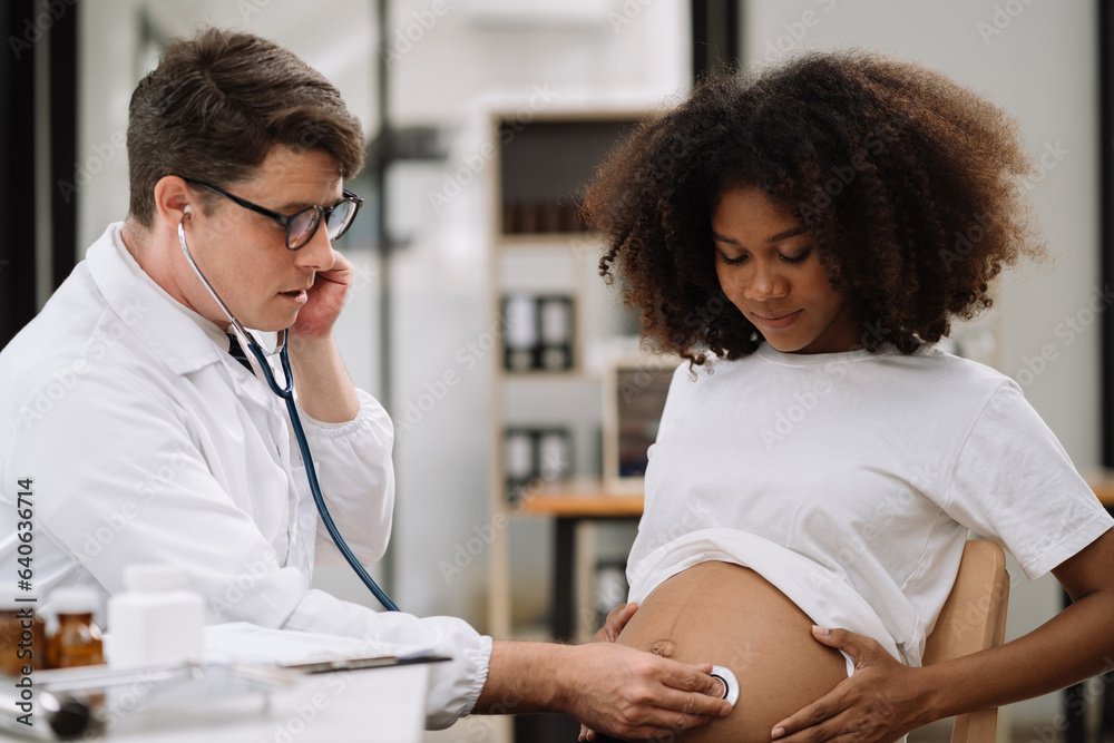 Happy pregnant woman has appointment with doctor at clinic. male medic ...
